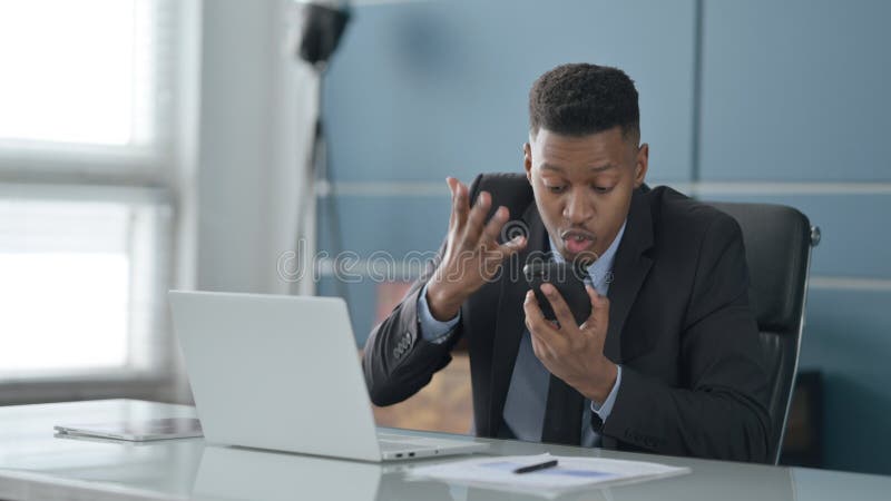 Angry African Businessman Talking on Smartphone in Office Stock Photo ...
