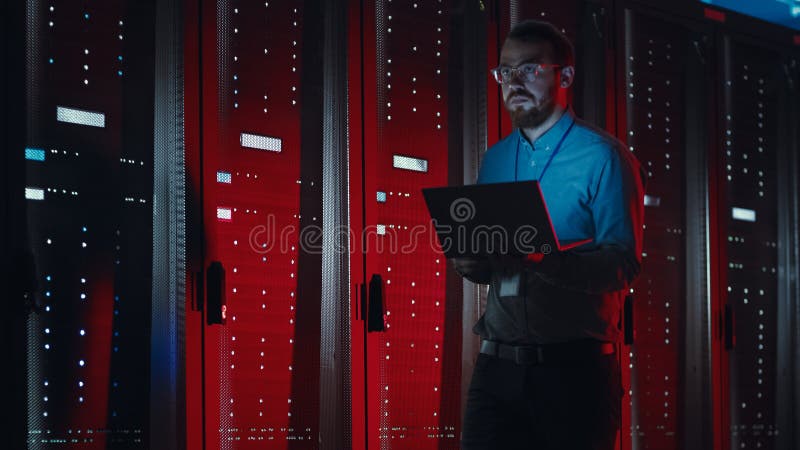Angry Bearded it Specialist in Glasses is Walking through Server Rack ...
