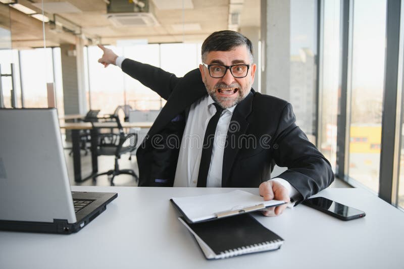 Angry Businessman Sitting at the Table and Screaming Over. Stock Image ...