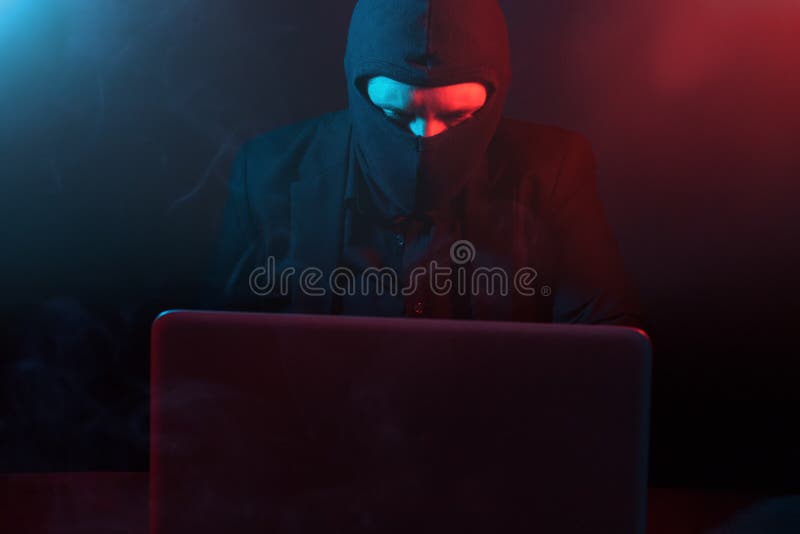 Angry Computer Hacker in Suit Stealing Data from Laptop Illuminated by ...