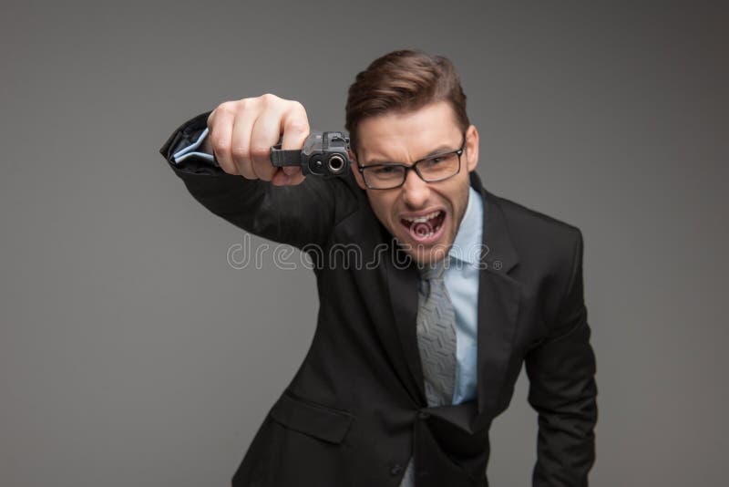Angry Criminal Businessman with Gun on Grey Background. Stock Photo ...