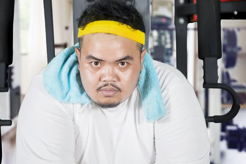 Angry Fat Man Sits on the Exercise Machine Stock Photo - Image of ...