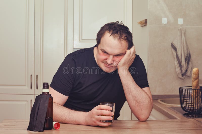 Angry Man Drinks Alcohol Sitting with a Bottle of Whiskey at the ...