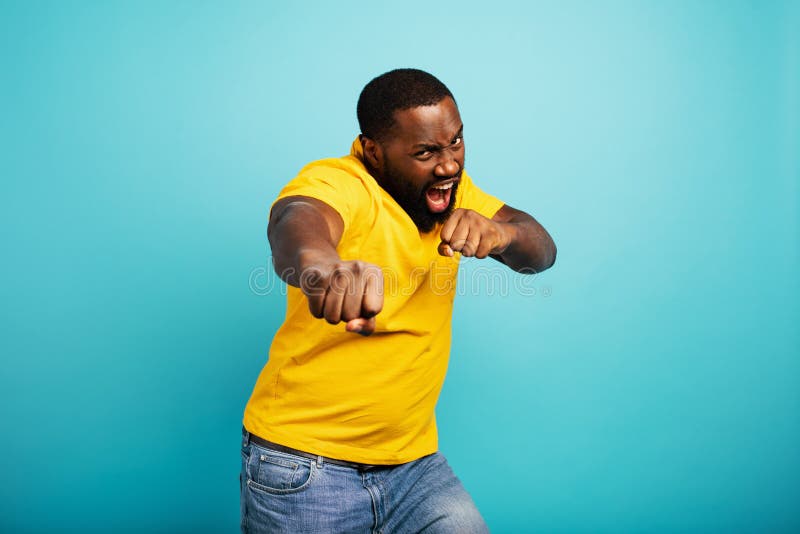 Man is Angry and Fights with Punches. Blue Background Stock Photo ...