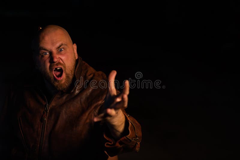 An Angry Man in a Leather Jacket Attacks in the Dark. Stock Photo ...
