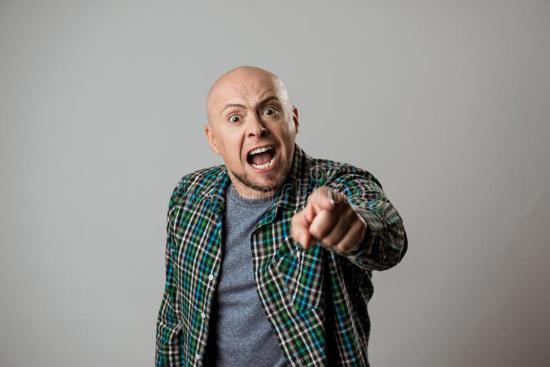 Angry Man Shouting, Pointing Finger at Camera Over Beige Background ... Angry Man Shouting, Pointing Finger at Camera Over Beige Background ...