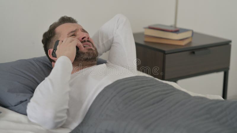 Angry Man Talking on Phone in Bed Stock Image - Image of talking ...