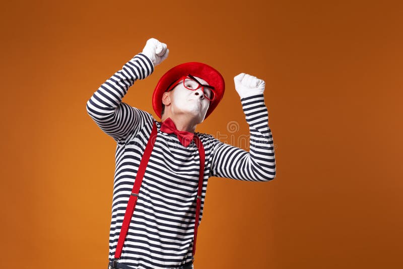 Sad Mime in Vest Holding Empty Red Hat on Orange Background Stock Photo ...