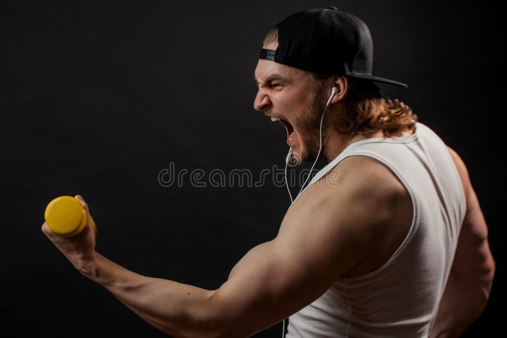 Angry Muscular Man is Training with Dumbbell Stock Photo - Image of ...