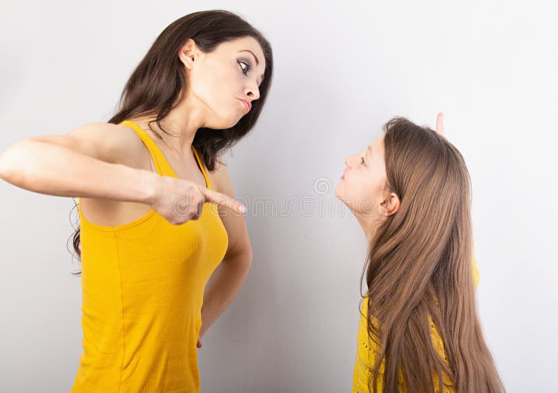 Angry Strict Mother Showing The Tongue And Her Emotional Anger Daughter