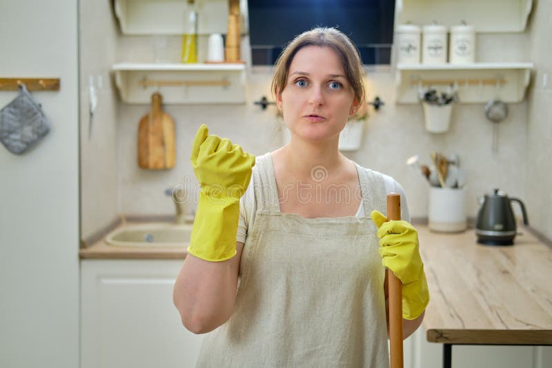 Angry Woman Shows Fist While Cleaning In Home Kitchen Stock Image