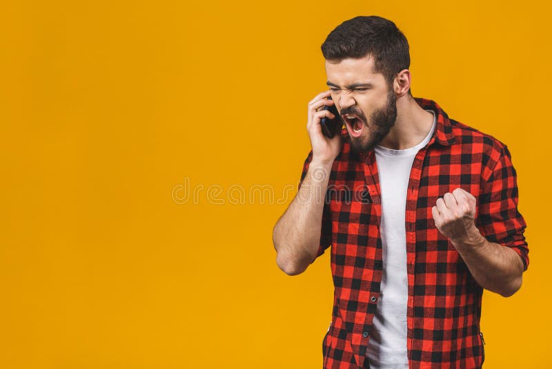 Angry Young Man Screaming on the Cell Phone Isolated on a Yellow ...