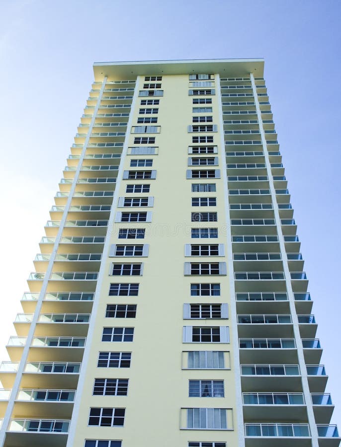 Yellow Building with Balconies and Plants Against Blue Sky Stock Photo ...
