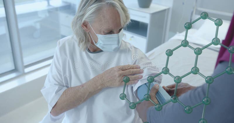 Animation of Element Structure Over Diverse Male Doctor Taking Pulse of ... Animation of Element Structure Over Diverse Male Doctor Taking Pulse of ...