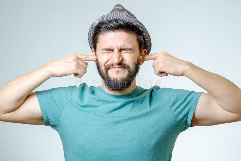 Annoyed Young Man Plugging Ears with Hands Stock Photo - Image of audio ...