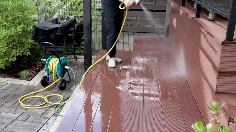 Anonymous Cleaning, Hose Washing Deck in Summer. Structures in Backyard ...