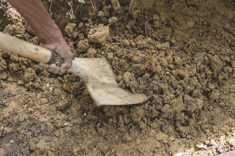 An Anonymous Man Digging into the Ground with a Shovel, Excavating a ...
