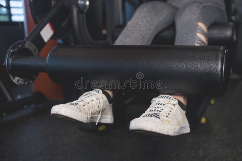An Anonymous Woman Does Leg Extensions. Using a Leg Extension Machine ...