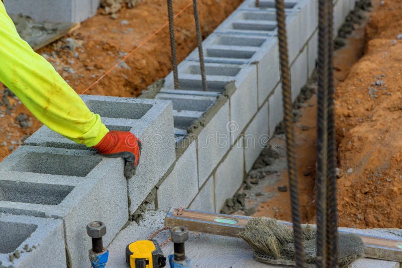 Another Row of Cement Blocks is Being Laid Down by a Bricklayer ...