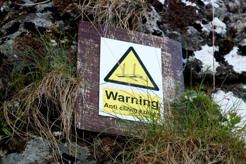 Anti Climbing Spikes Warning Sign on a Stone Castle Wall Stock Photo ...