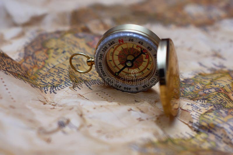 Antique Brass Compass Resting on a World Map, Symbolizing Travel and ...