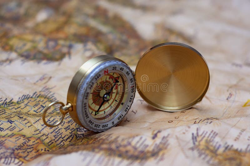 Antique Brass Compass Resting on a World Map, Symbolizing Travel and ...