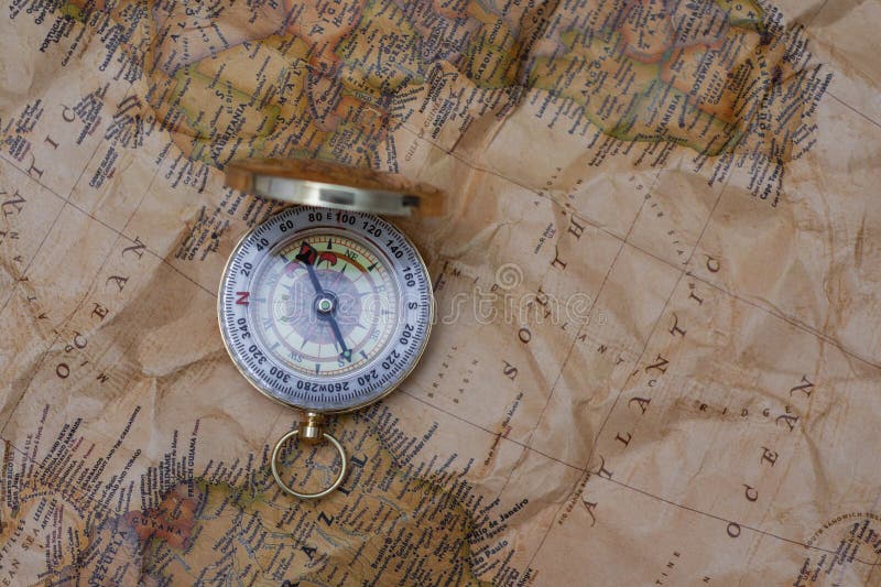 Antique Brass Compass Resting on a World Map, Symbolizing Travel and ...