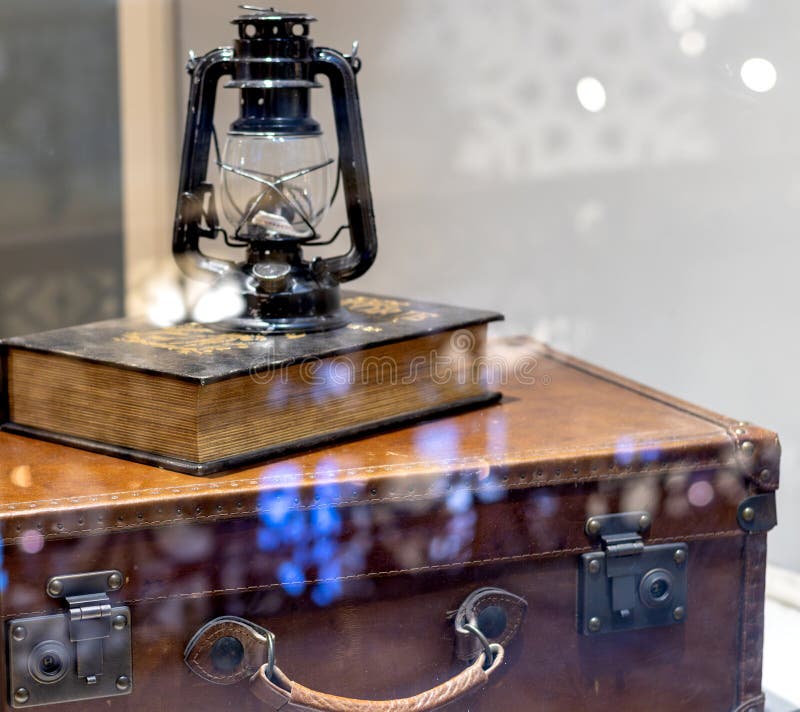 Antiques on Display. Suitcase, Book and an Oil Lamp Stock Photo - Image ...