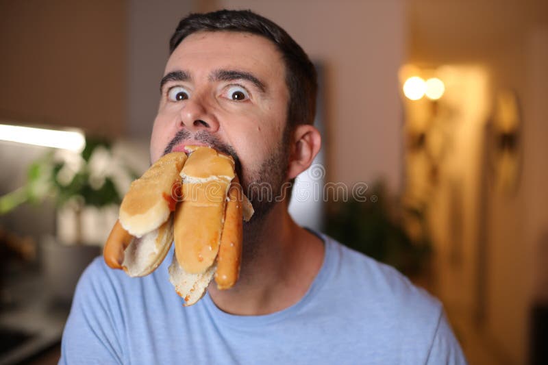 Anxious Man Eating Two Dogs at the Same Time Stock Photo - Image of ...