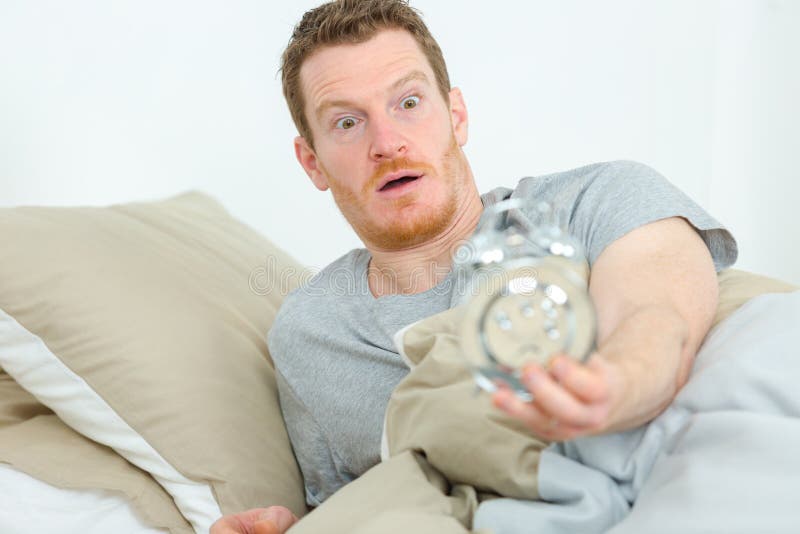 Anxious Young Man Looking at Alarm Clock Stock Image - Image of time ...