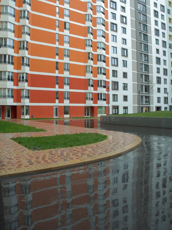 Apartment Building Reflected on Wet Pavement Stock Image - Image of ...
