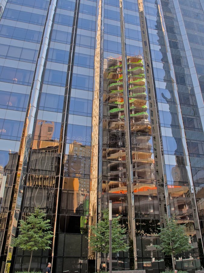 Apartment Building Under Construction Reflecting in the Glass Wall of a ...