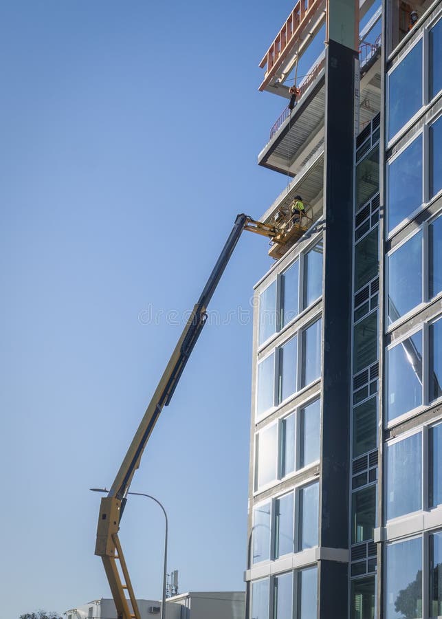 Apartment Under Construction. Crane Lifting Building Materials and ...