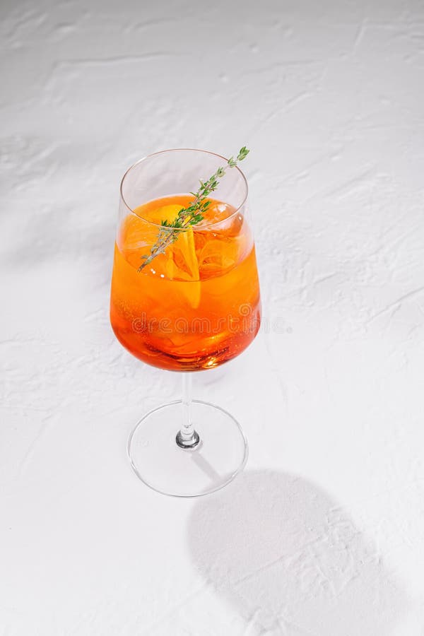 Aperol Spritz Cocktail Standing on White Table with Thyme Garnish Stock ...