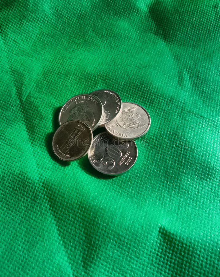 The Appearance of Coins that are Stacked on a Stretch of Green Cloth ...