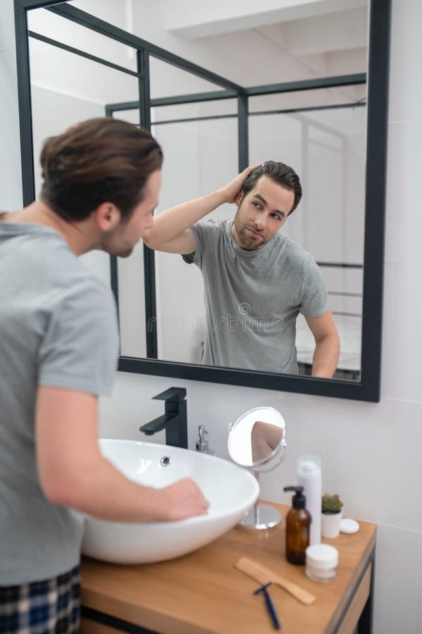 Man Near the Mirror Scrutinizing Himself Stock Photo - Image of face ...