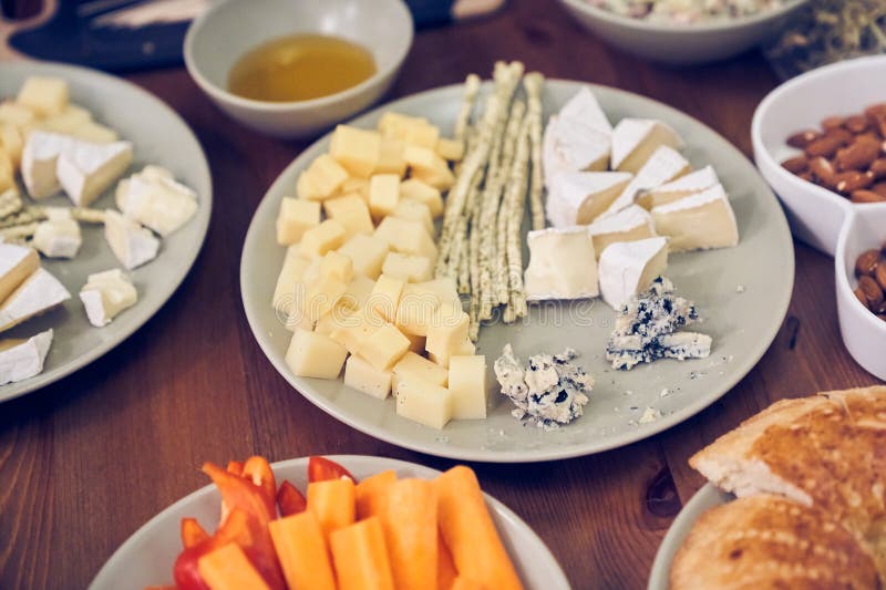 An Appetizer of Different Types of Diced Cheese is on the Plate. Honey ...