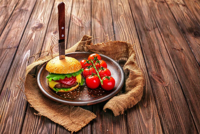 Appetizing Burger with Tomatoes on Table Stock Photo - Image of ...