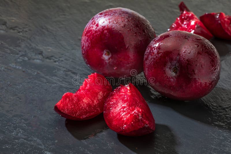 Appetizing and Healthy Red Plums, Whole and Cut into Segments with a ...