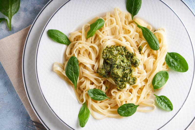 Appetizing Pasta with Sauce Pesto and Spinach in Plate on Light Blue ...