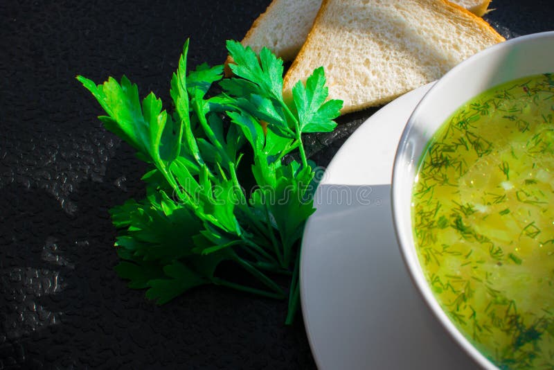 Appetizing Chicken Broth Soup on a Black Table with Bread and Parsley ...