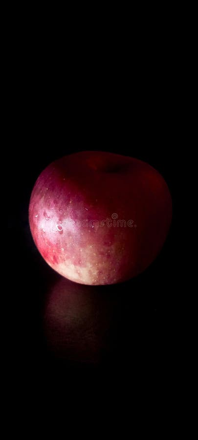 An apple in the dark stock photo. Image of fruit, violet - 262778894