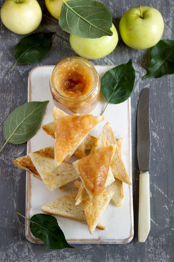 Apple Jam in a Glass Jar with Bread Toasts and Ripe Apples on a Wooden ...
