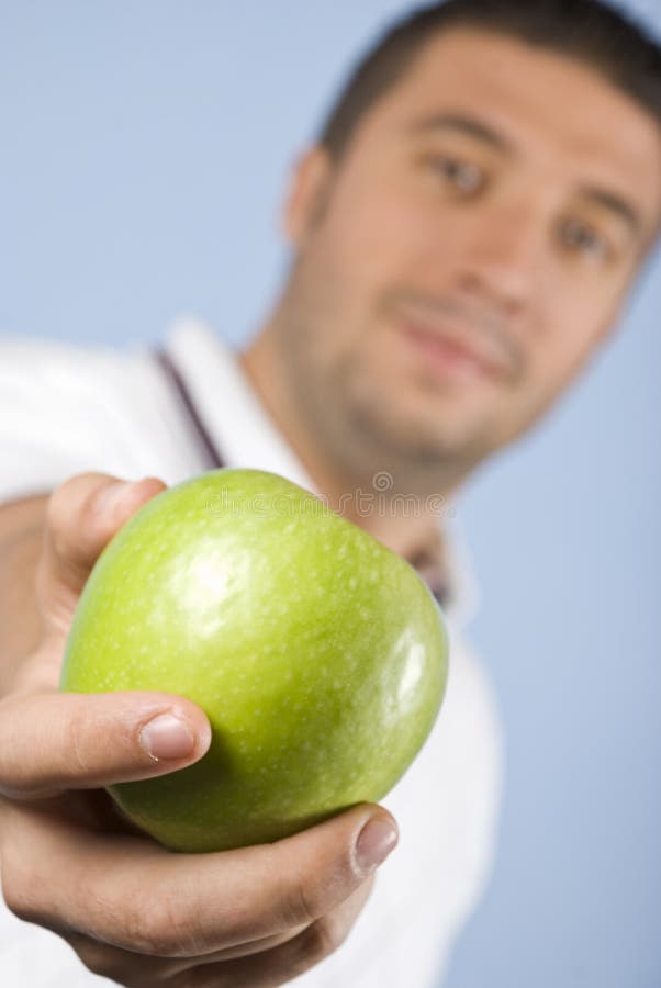 Man in a Suit and Hat Standing Near the Wall with a Green Apple in ...
