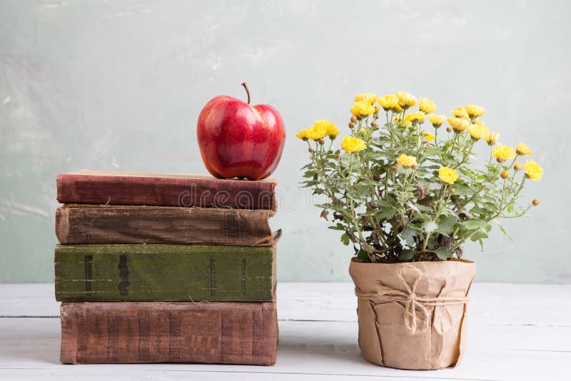 Apple on a Stack of Books on the Table with Flowers Stock Photo - Image ...