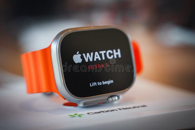 An Apple Watch, One Silver with Orange Band, One Dark with Black Loop ...