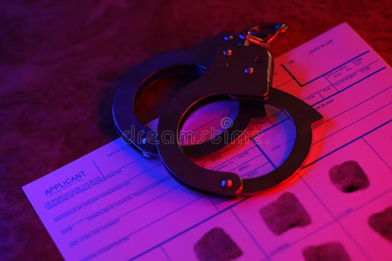 Applicant Or Fingerprints Card With Police Handcuffs On Table In Dark