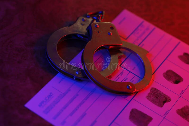 Applicant Or Fingerprints Card With Police Handcuffs On Table In Dark