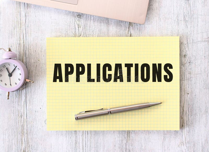 APPLICATIONS Text Written in a Notebook Lying on a Wooden Work Table ...