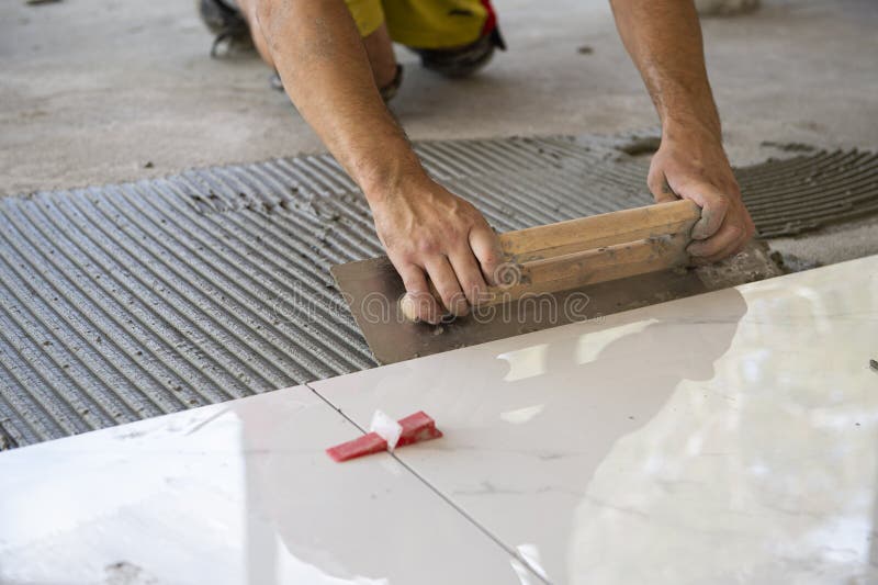 Ceramic White Floor Tiles Laid Over Adhesive with a Tile Leveling ...